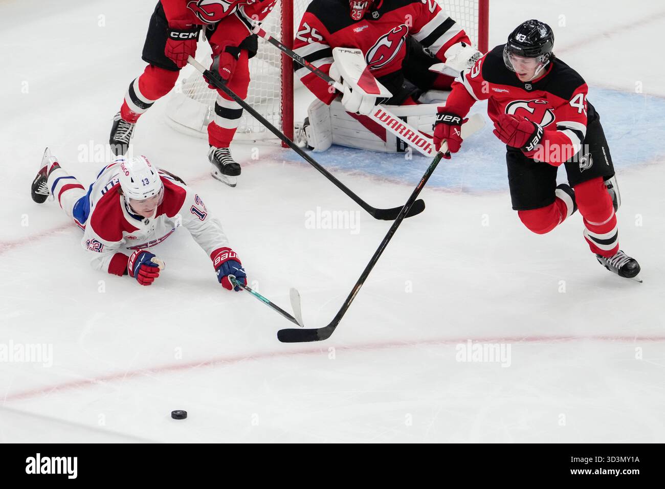New Jersey Devils defenseman Luke Hughes (43) fights for control of the ...