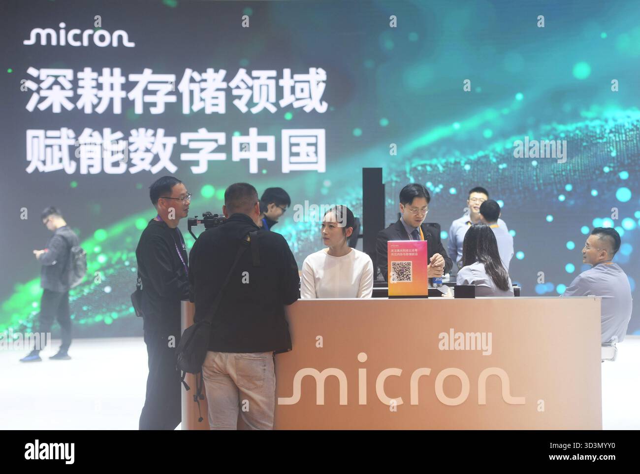 People visit the booth of Micron, a U.S..-based manufacturer of ...