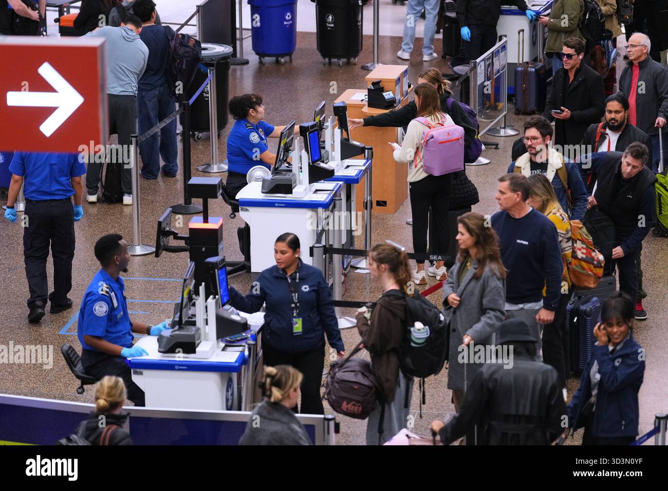 Travelers wait at a security checkpoint at Seattle-Tacoma International ...