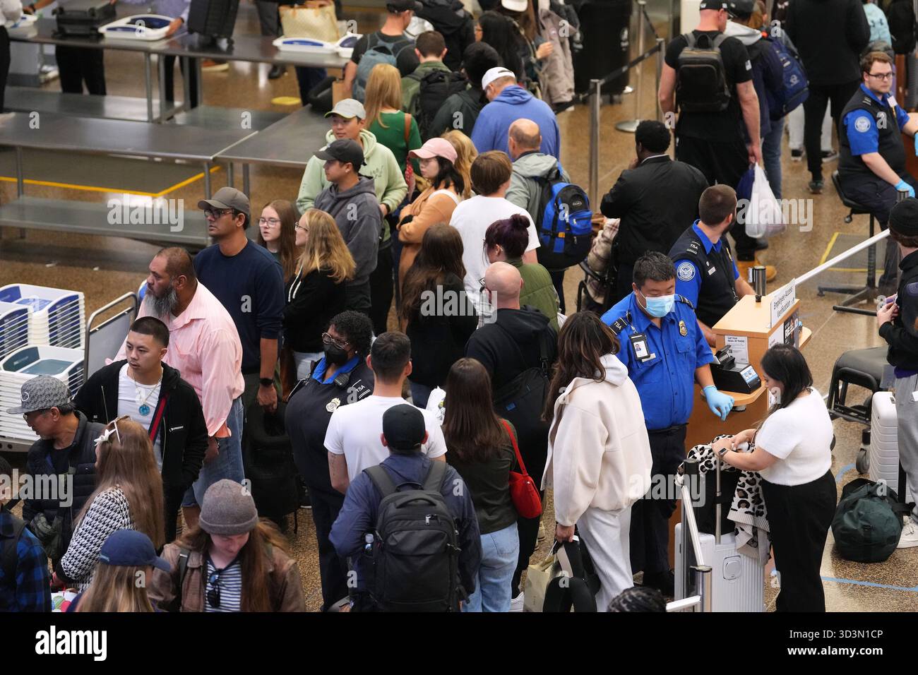 Travelers wait in line at a security checkpoint at Seattle-Tacoma ...