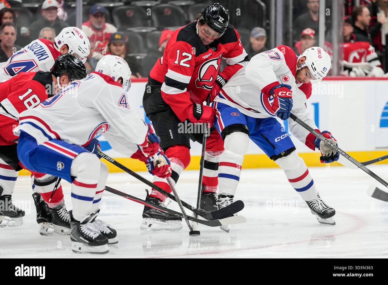 New Jersey Devils center Cody Glass (12) fights for control of the puck ...