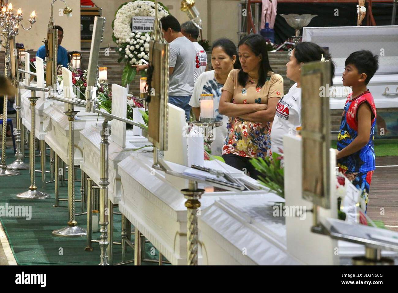 People stand near coffins in Bacayan, Cebu province, Philippines on ...