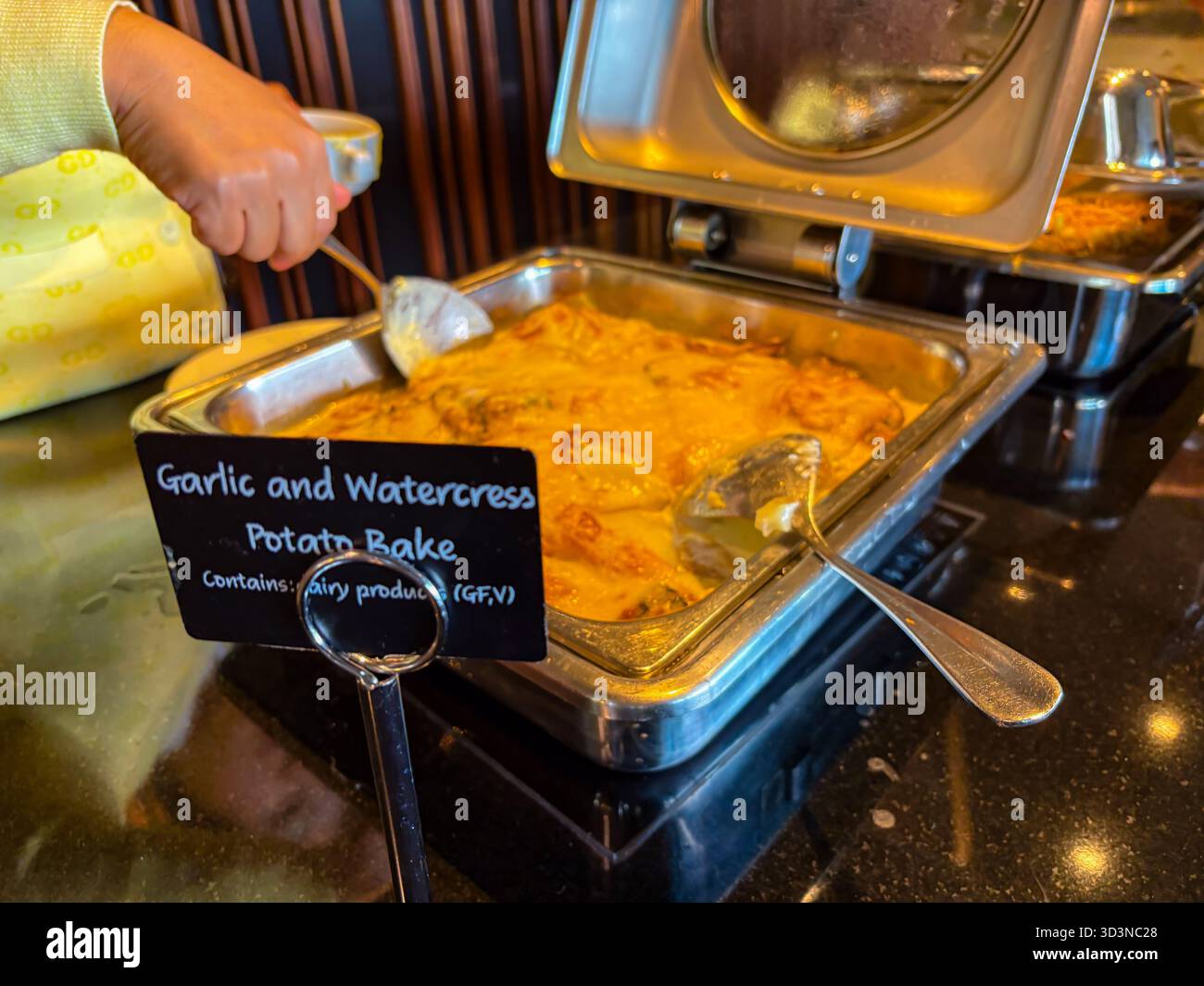 Garlic and watercress potato bake served from a buffet chafing dish at ...