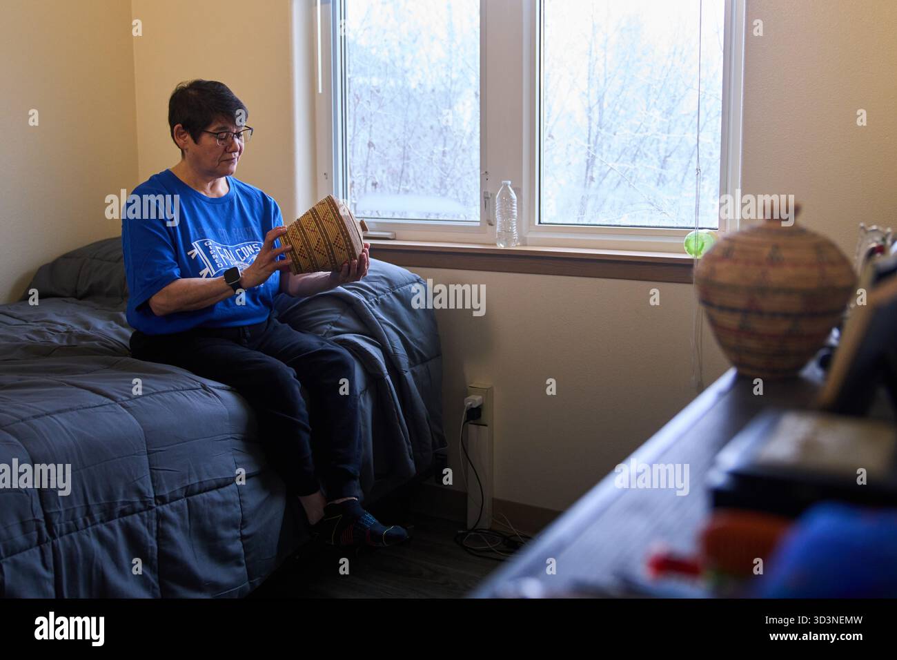 Louise Paul looks at a grass basket salvaged from her family's home ...