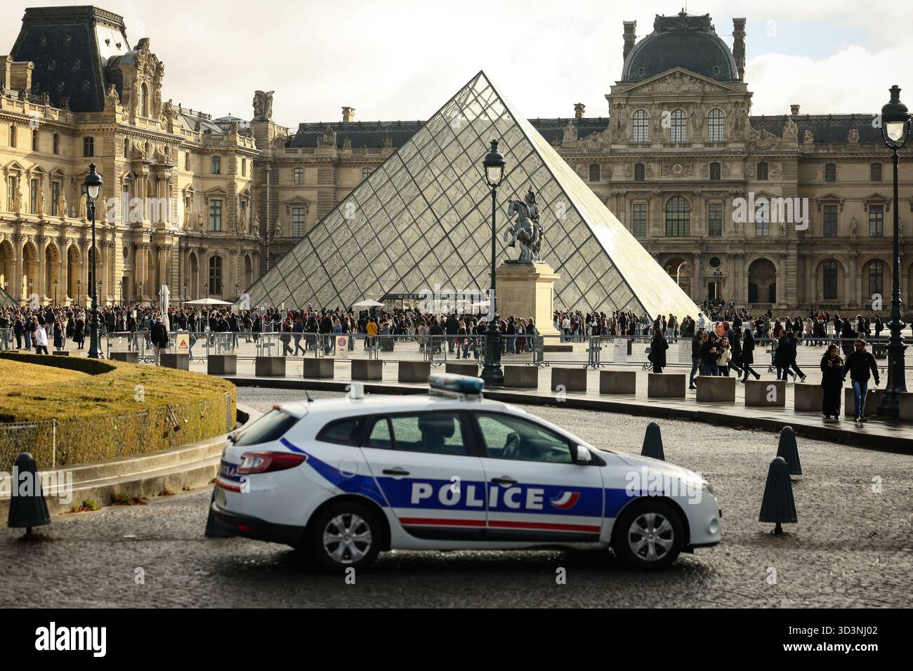 FILE - A police car parks in the courtyard of the Louvre museum, one ...
