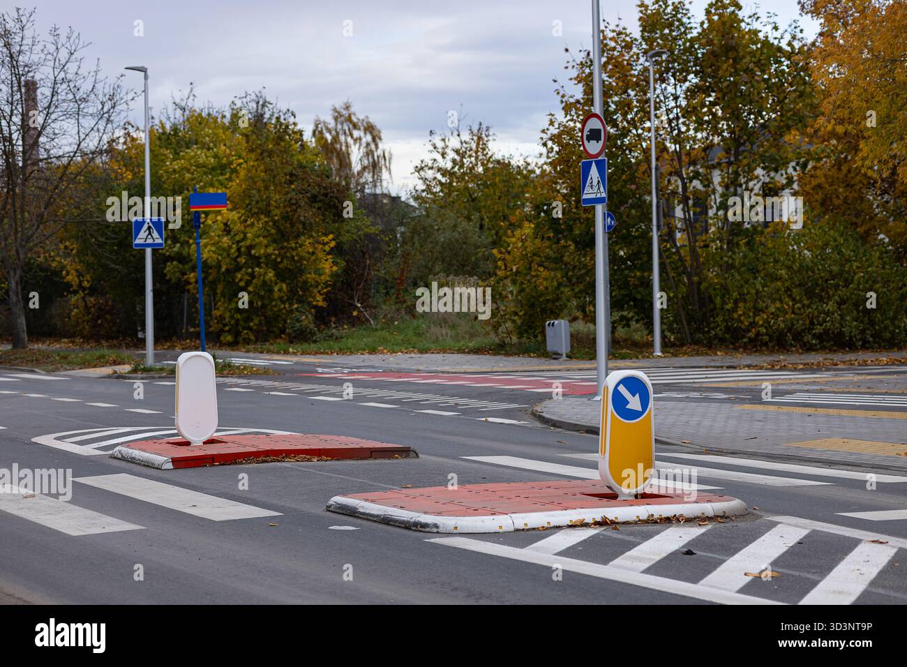 Urban road intersection with various traffic signs and pedestrian ...