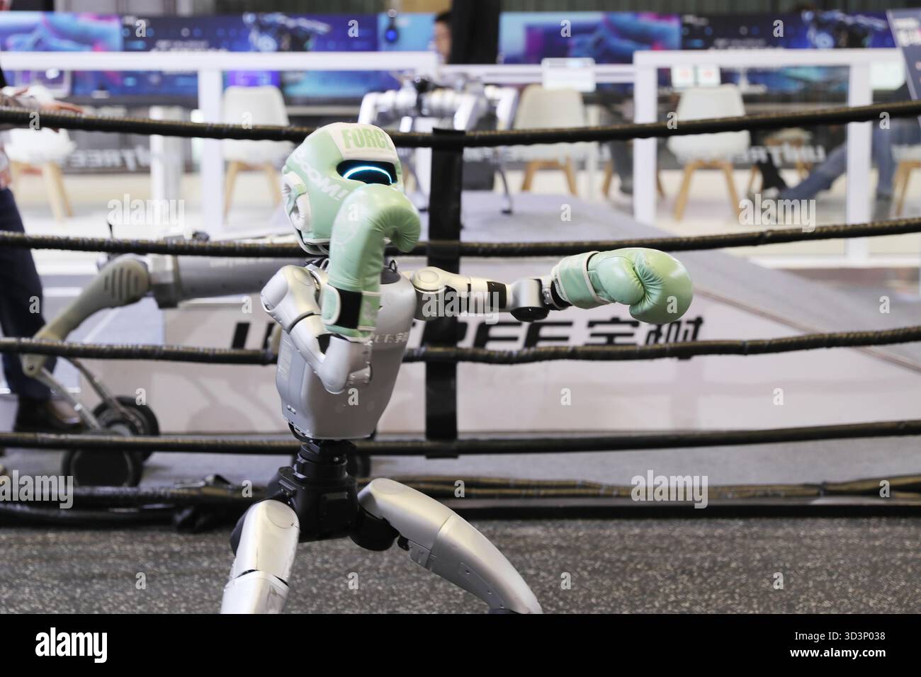 Visitors watch a robot boxing game at the 8th China International ...