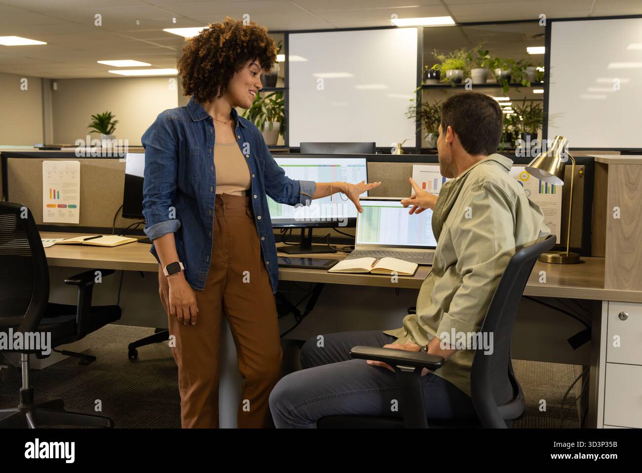 Analyzing Diverse coworkers pointing at spreadsheet data in open ...
