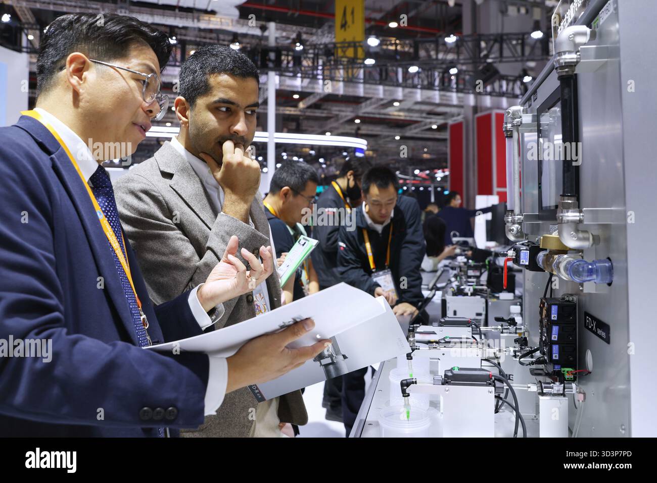 Foreign visitors learn about the clamp-on flow sensor at the KEYENCE ...