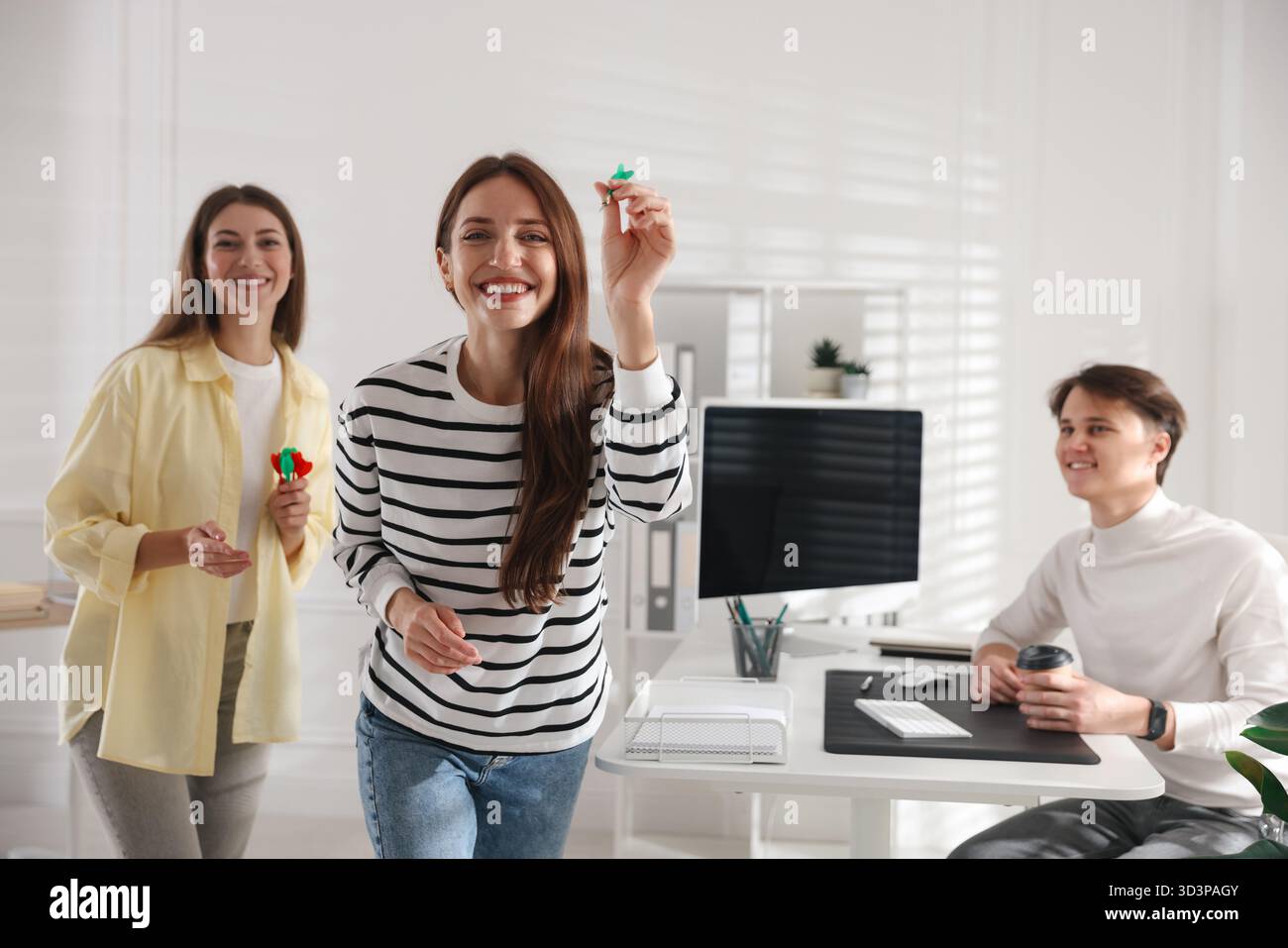 Woman playing darts and her colleagues in office Stock Photo - Alamy