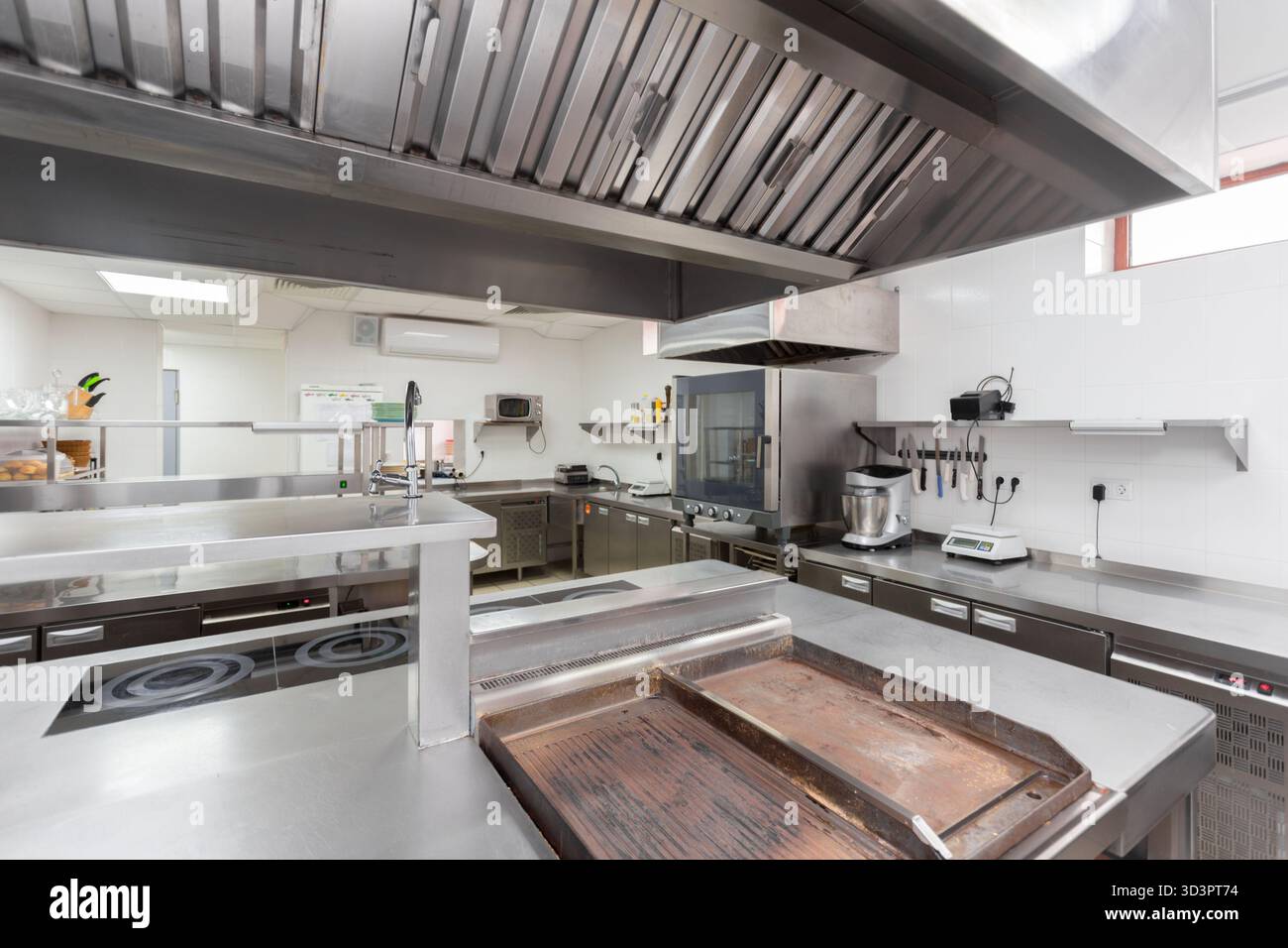 Modern commercial kitchen with stainless steel appliances and organized ...