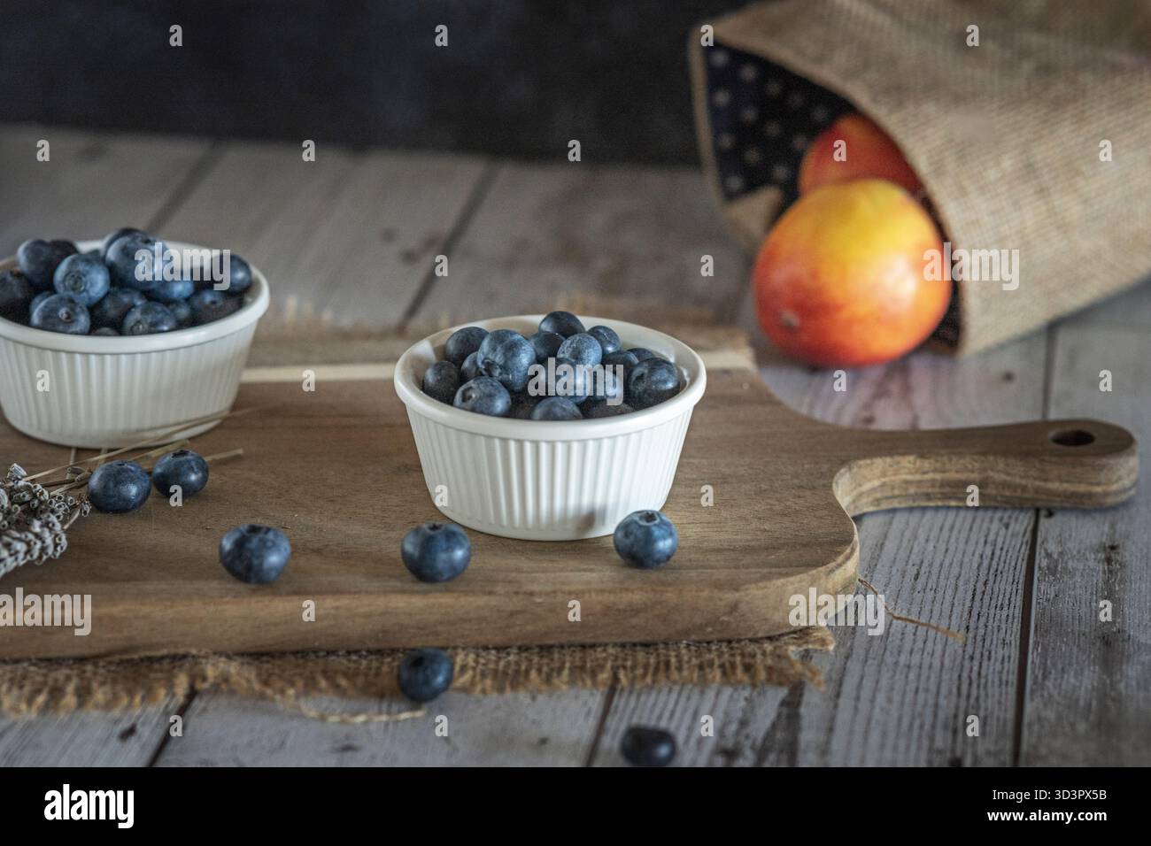 The simplicity of the blueberries on the rustic wood conveys a sense of ...