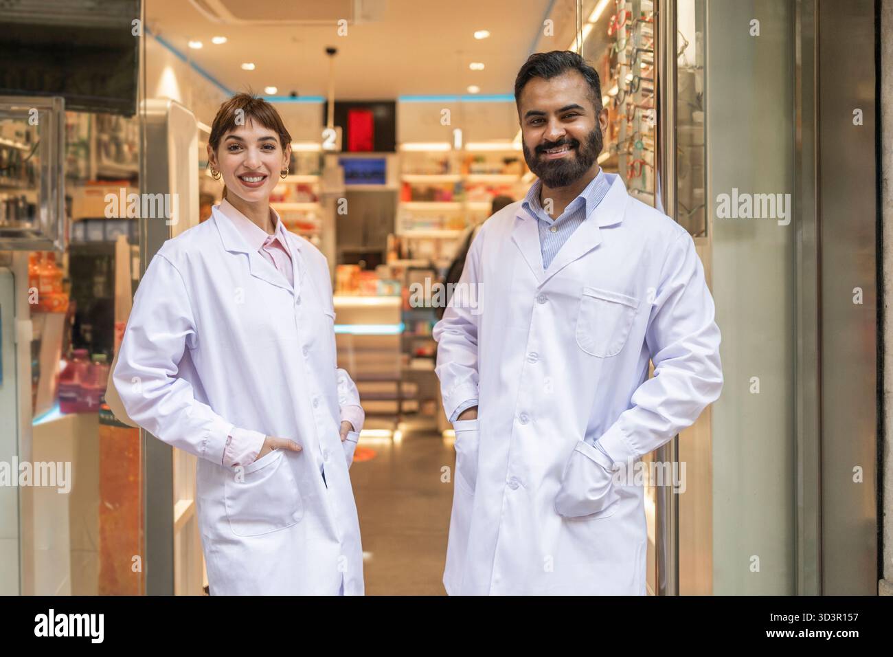 Two pharmacists in white lab coats stand confidently outside a well ...