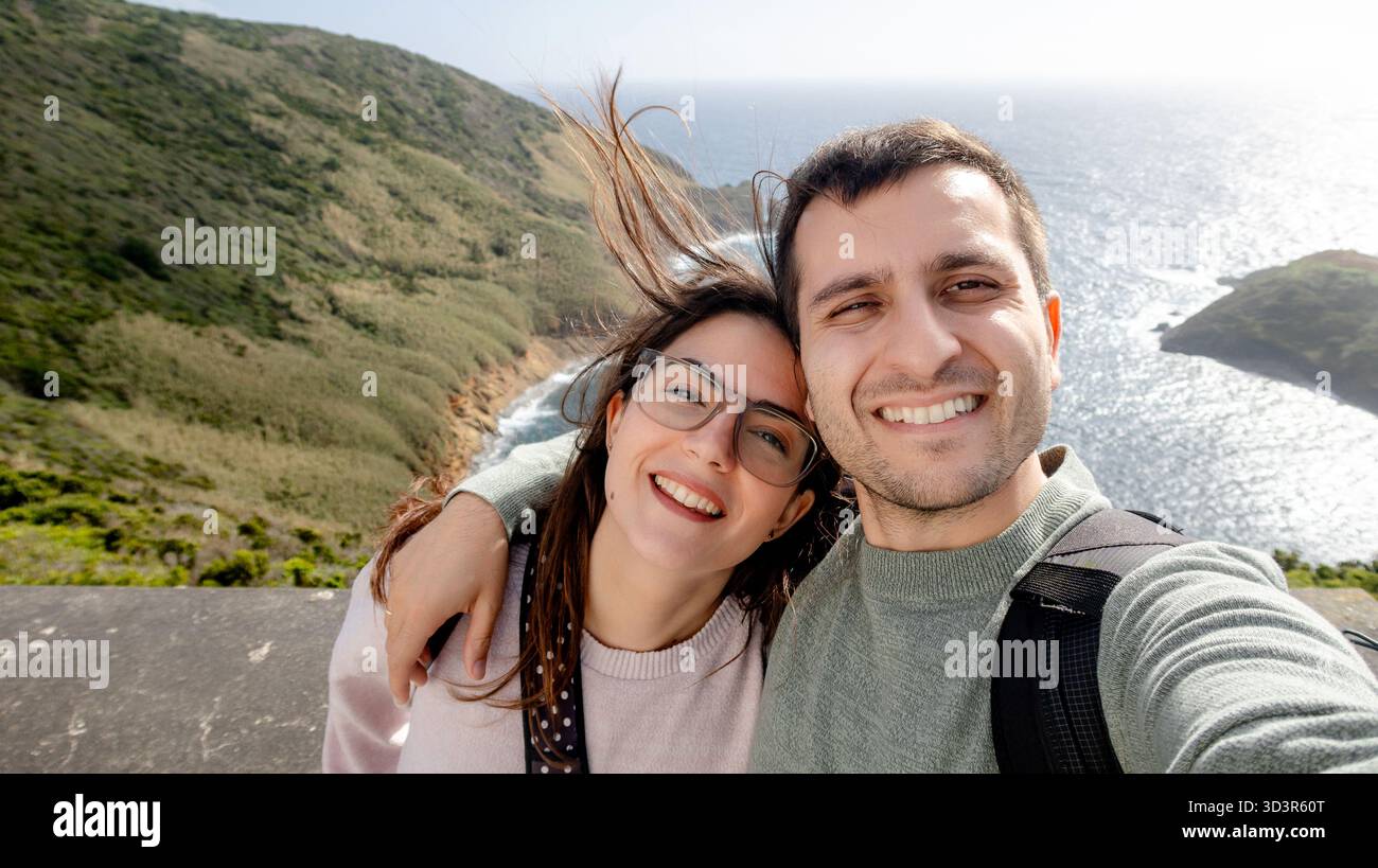 A smiling couple takes a selfie with the stunning Caldeira do Inferno ...