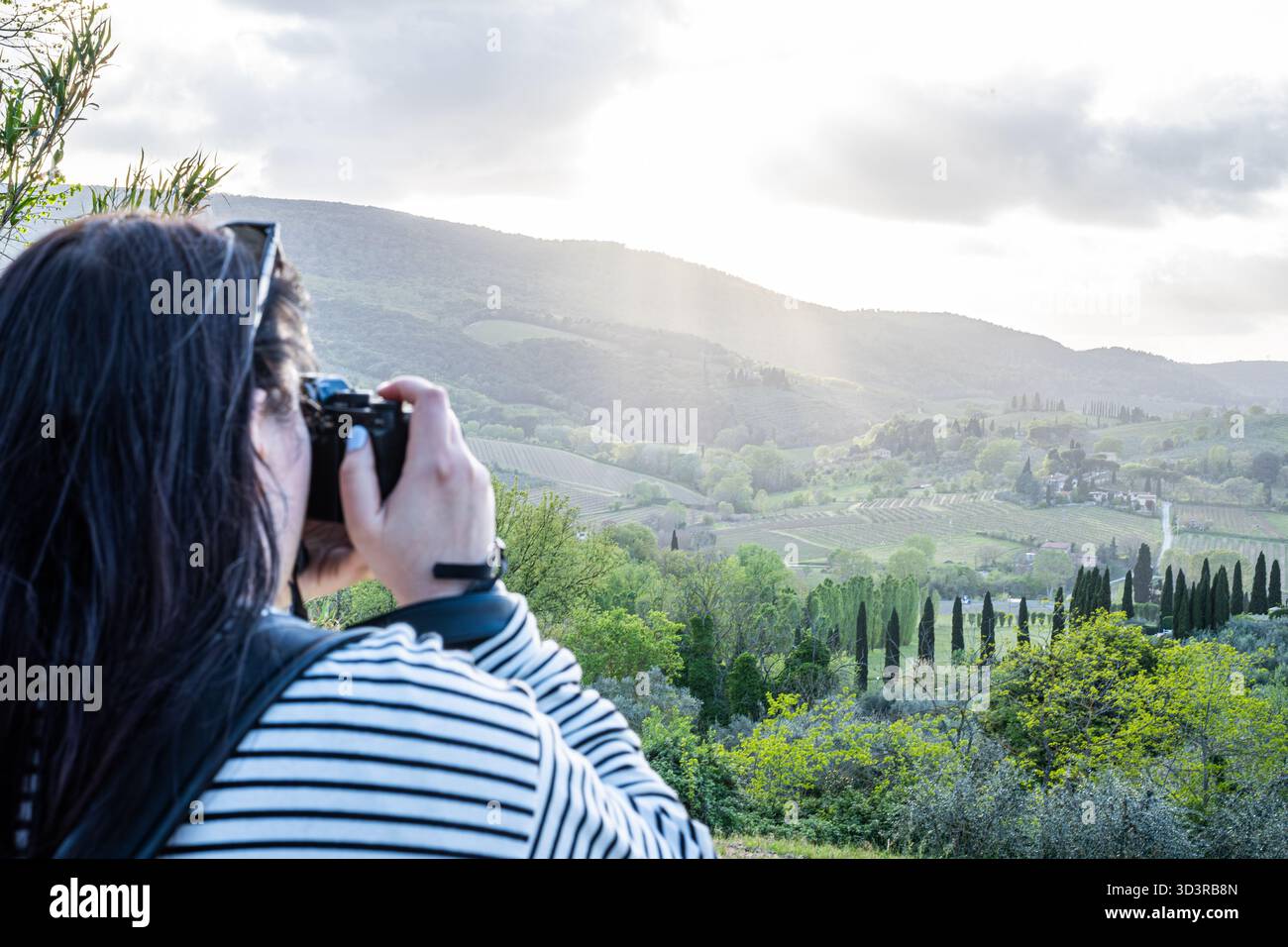 Female photographer taking pictures of a picturesque landscape ...