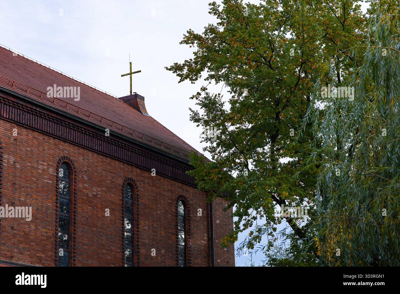 Brick church structure features a prominent cross atop the roof ...
