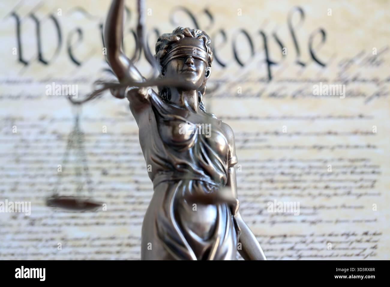 Lady Justice bronze statue and US Constitution blurred page close up ...