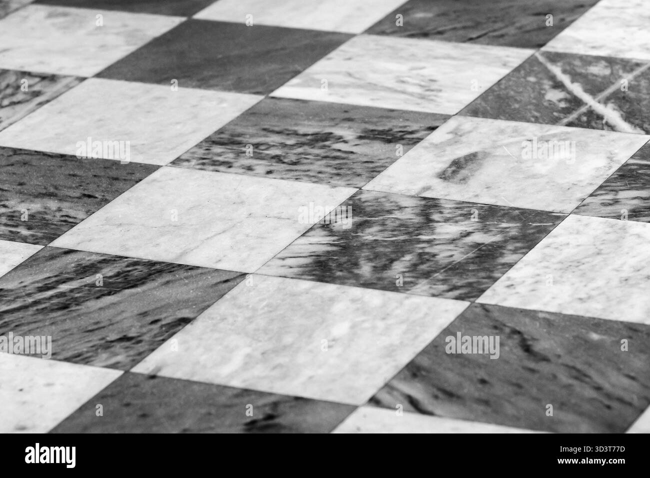 A close-up view of a black and white checkered marble floor, featuring ...