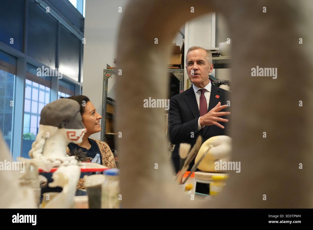 Prime Minister Mark Carney is seen framed through a sculpture as he ...