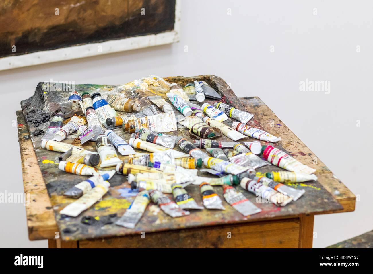 Artists workspace featuring a collection of used paint tubes and a well ...