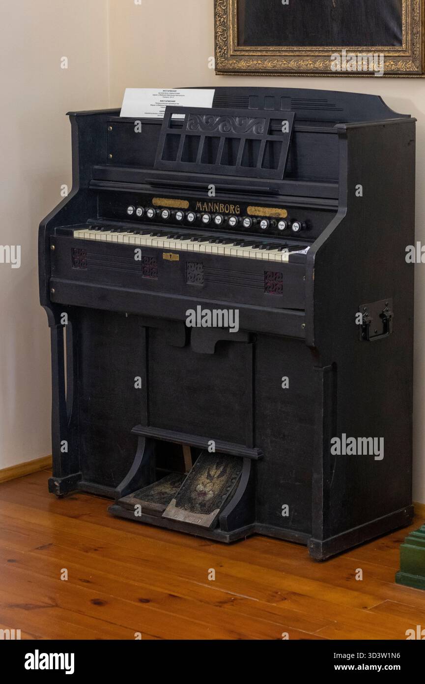 The image shows a Mannborg harmonium, also known as a reed organ or ...