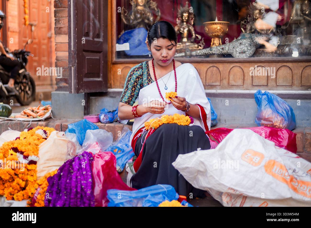 Newari Girl in traditional attire Crafting Globe Amaranth Garlands ...