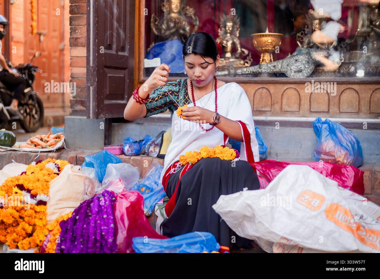 Newari Girl in traditional attire Crafting Globe Amaranth Garlands ...