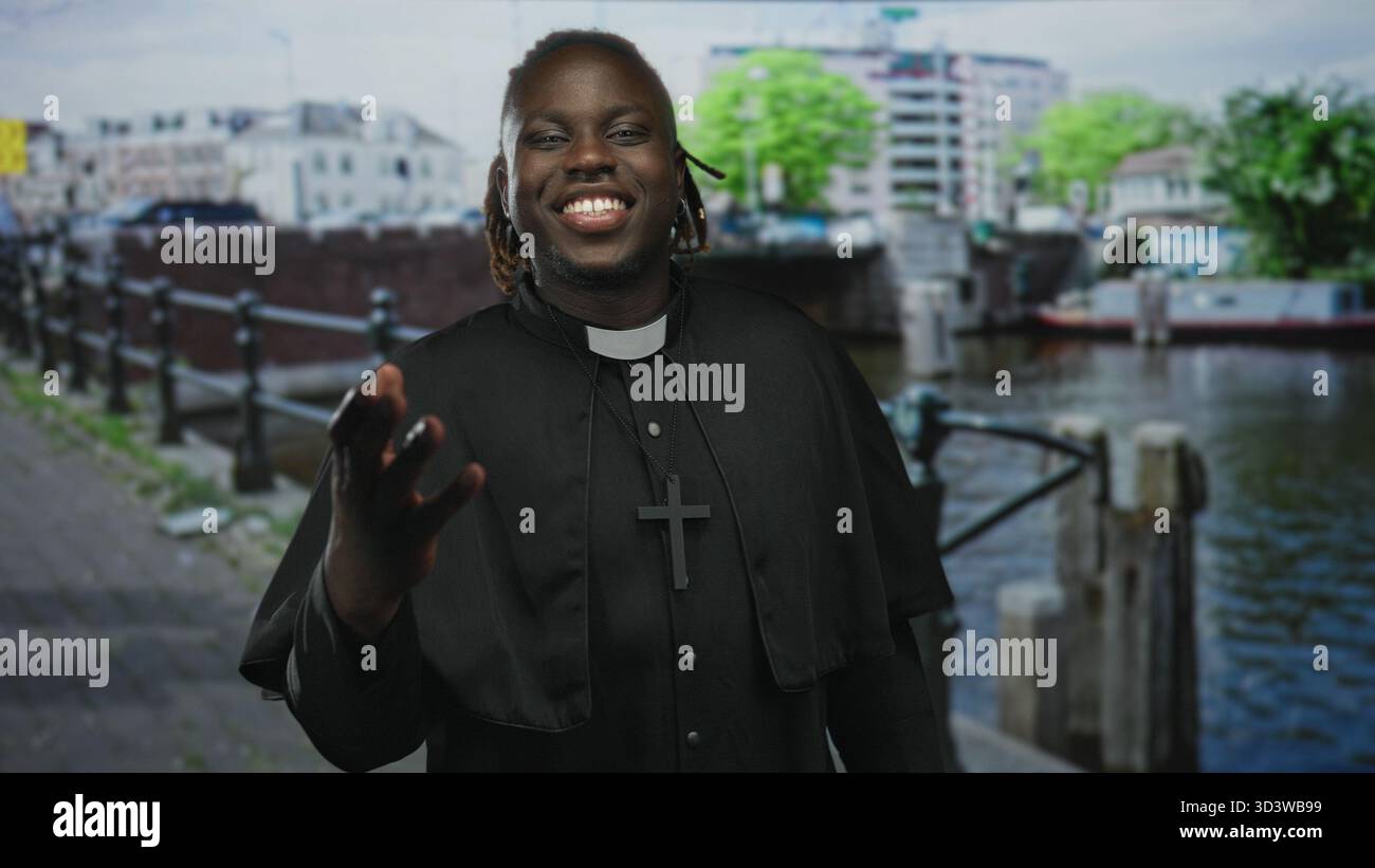 Man priest gestures with open hands on a street by an amsterdam canal ...