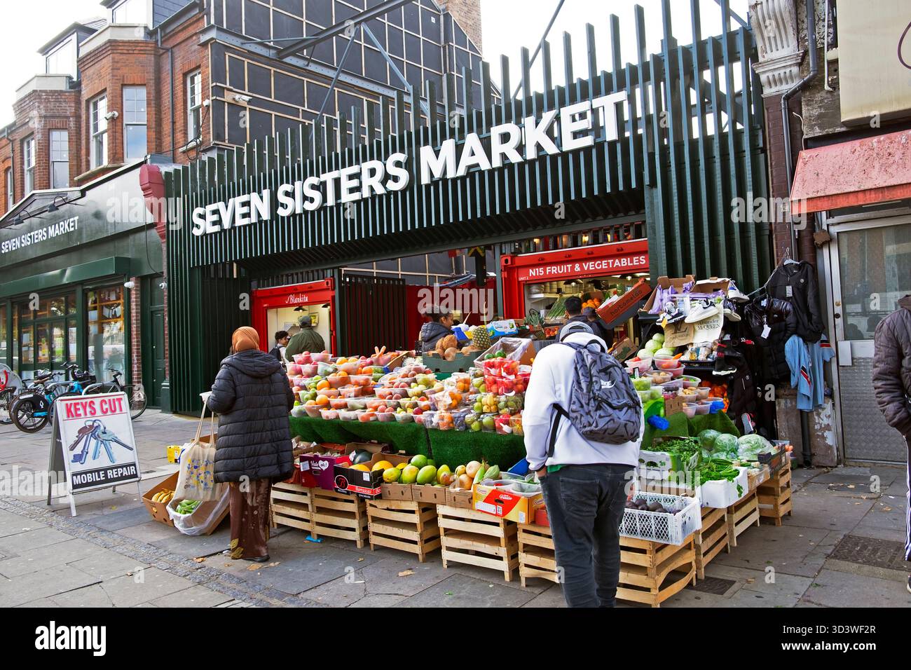 People outside Seven Sisters Market sign entrance exterior in Tottenham ...