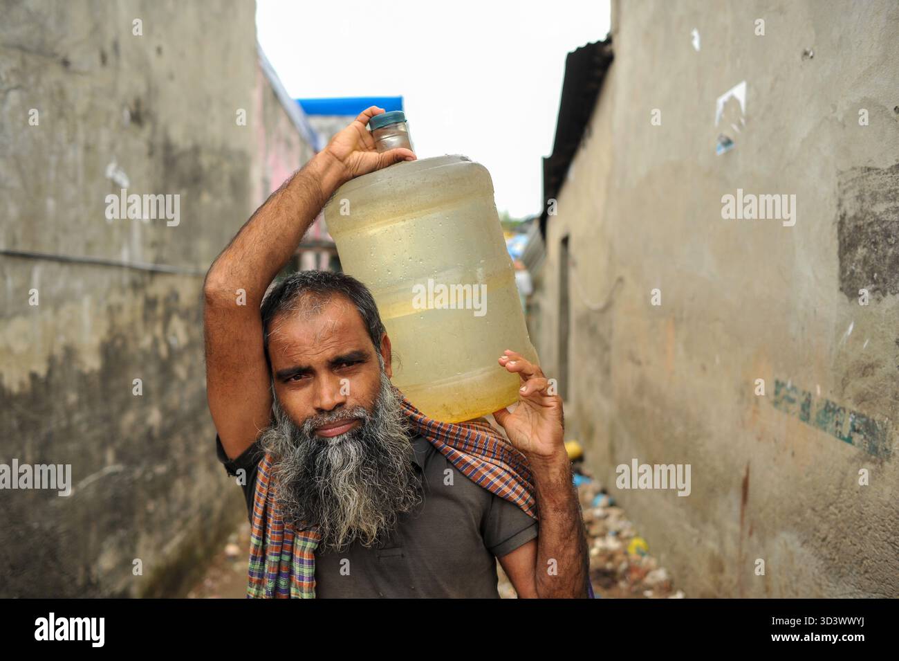 A man carry a large pot collect water from a deep tube-well in Bakalia ...