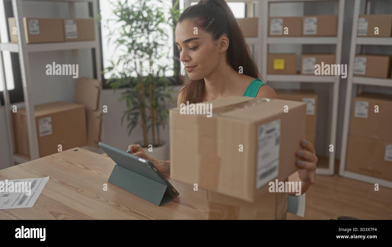 Woman holds cardboard package and checks shipping label at office ...