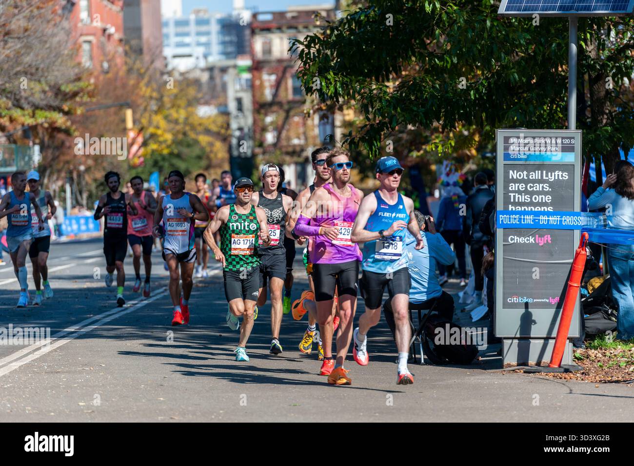 Runners pass through Harlem in New York near the 22 mile mark near ...