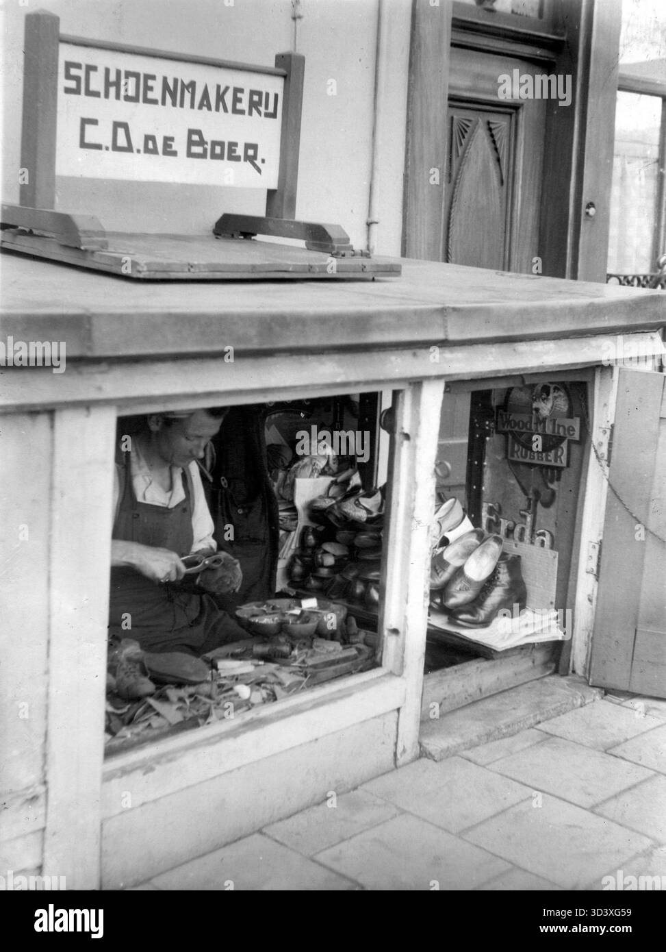 A shoemaker works in his workshop located in a basement (pothuis) in ...