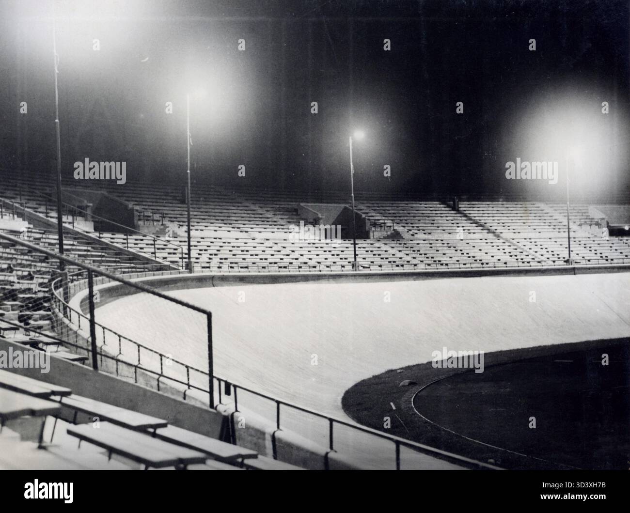 The Olympic cycling track at night, illuminated by streetlights, during ...
