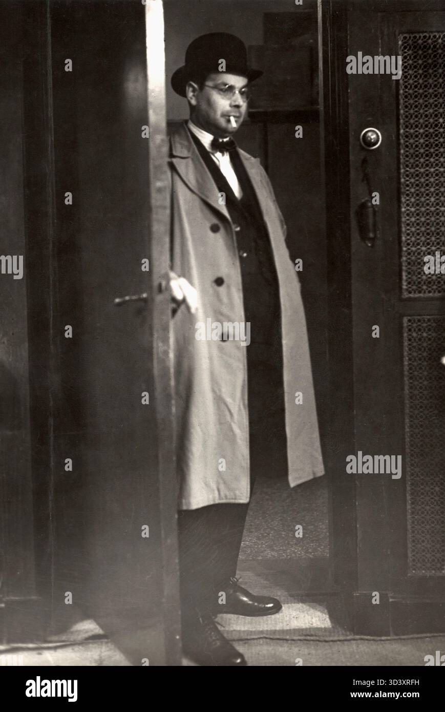 Oscar Tourniaire (1880-1939), actor, standing in an open door wearing a ...