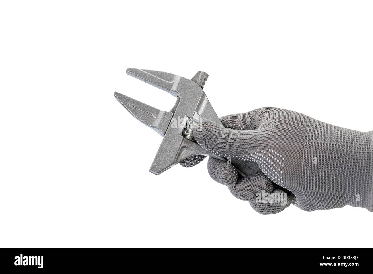 A gloved hand holds small width wrench against white background ...