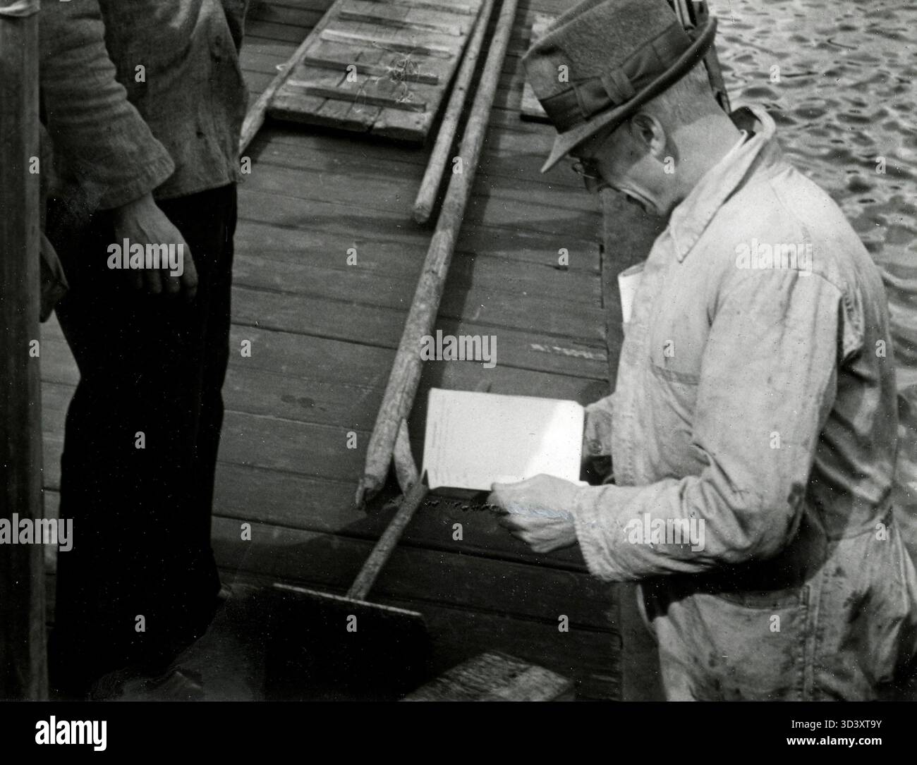 In 1940, a ship's master checks the measurement of a riverboat by the ...