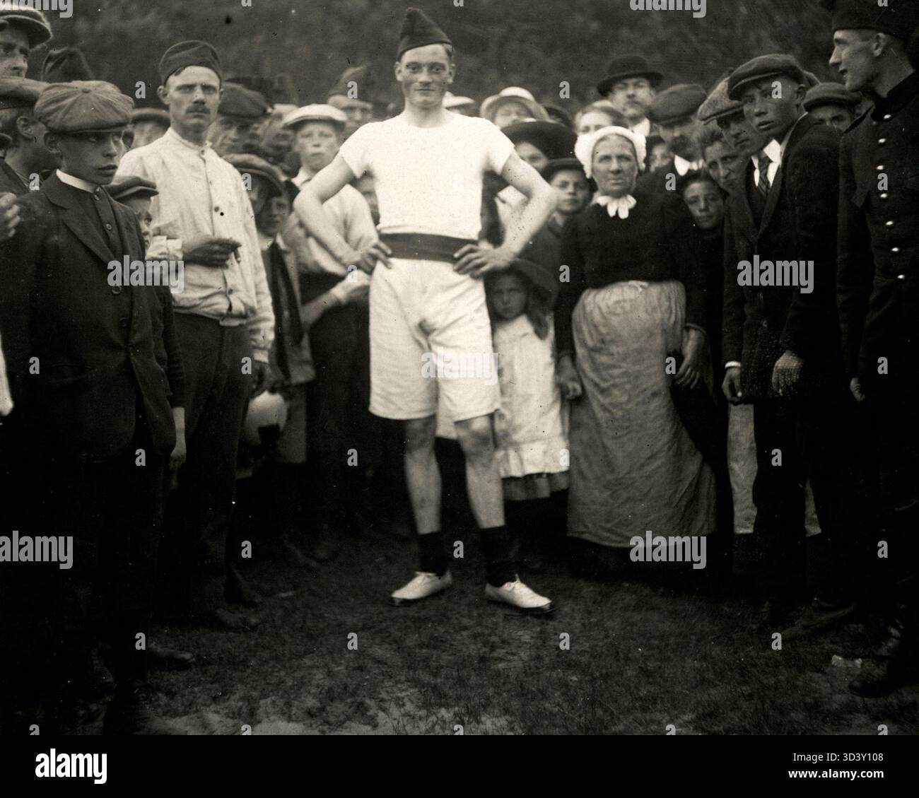 A Dutch soldier in sports attire poses proudly surrounded by onlookers ...