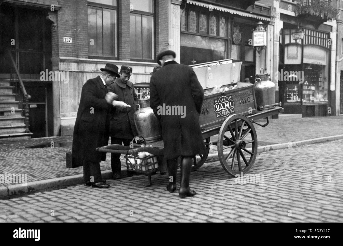 Health inspectors check milk in milk cans on a handcart as part of ...