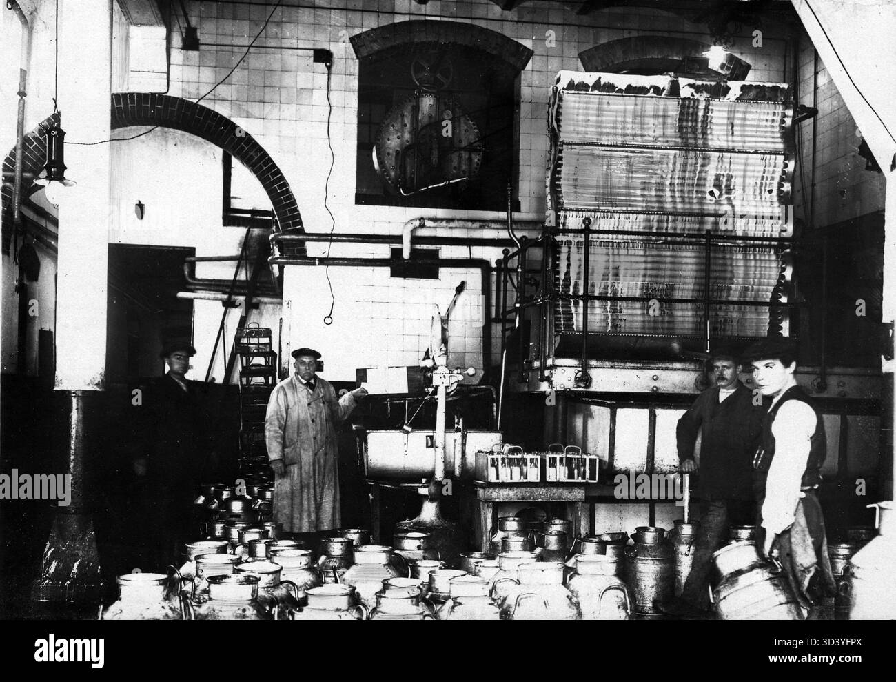 Men with milk cans work at a pasteurization facility to disinfect milk ...