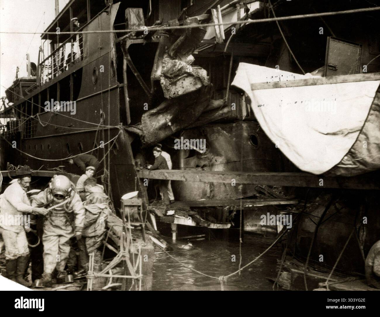 A diver descends from the torpedo-damaged hull of the British auxiliary ...