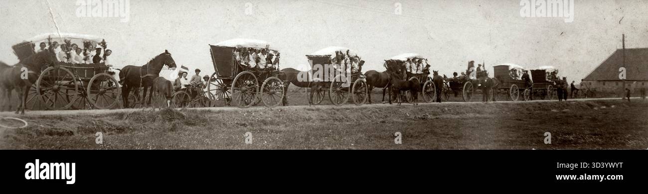 In 1916, a long procession of carriages moves down a road during the ...