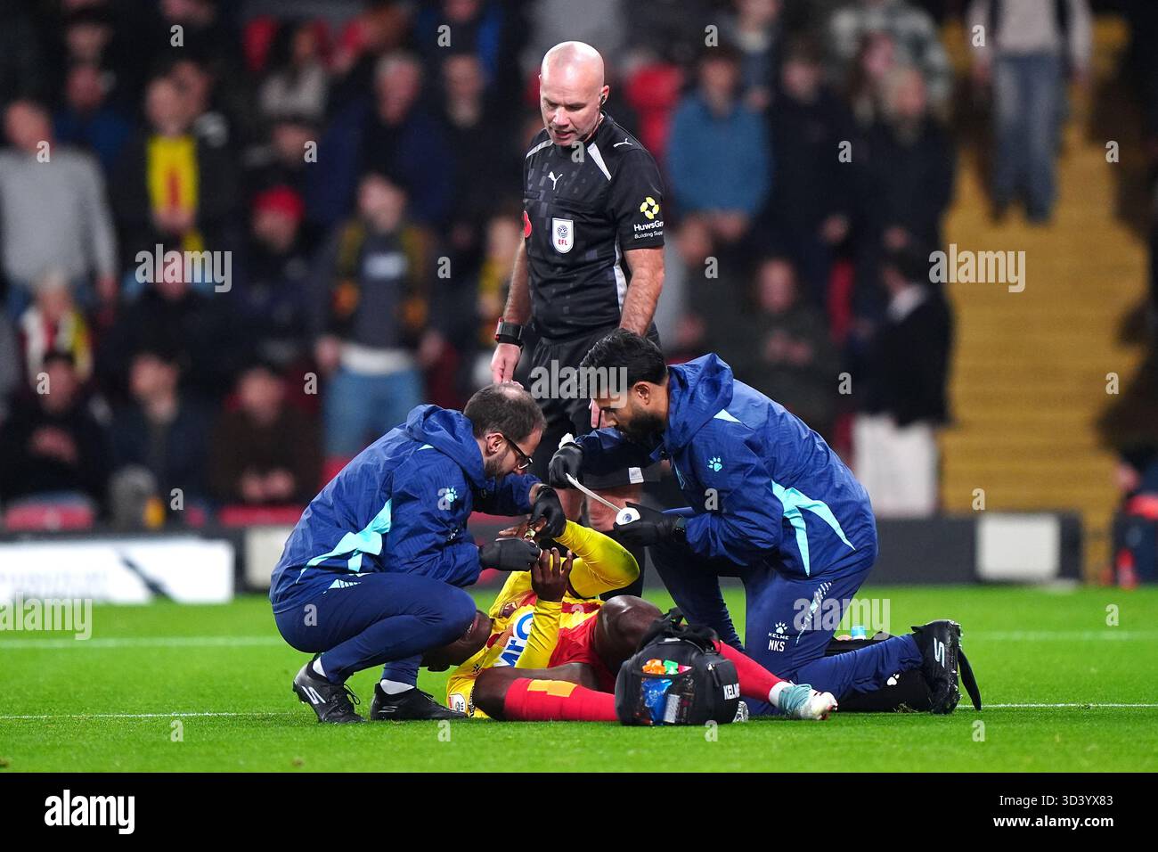 Watford's Marc Bola receives treatment for an injury after scoring ...