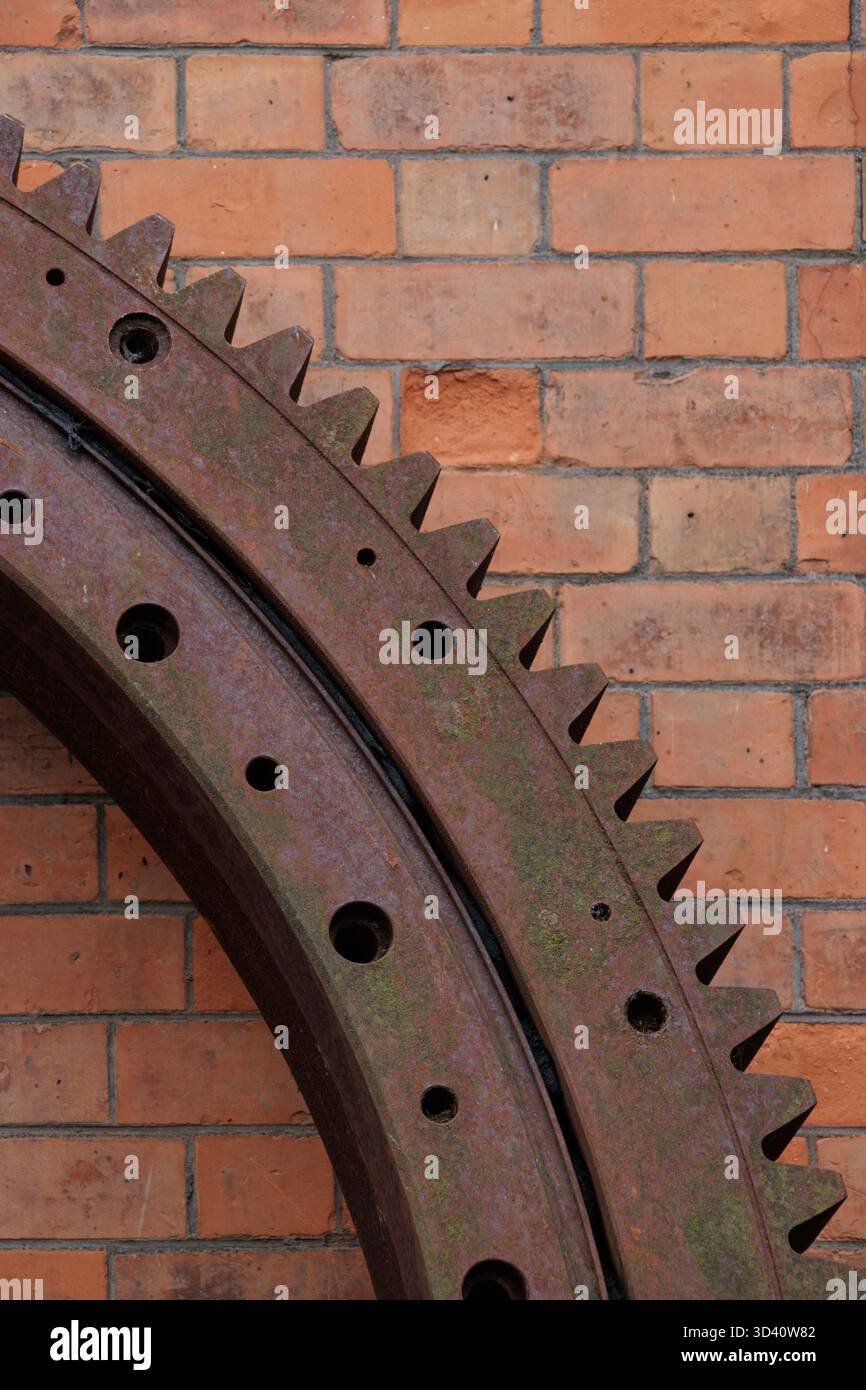 Large rusty industrial metal cog wheel and brick wall Stock Photo - Alamy