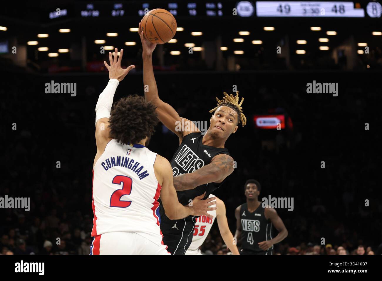 Brooklyn Nets forward Noah Clowney looks to pass the ball around Detroit Pistons guard Cade ...