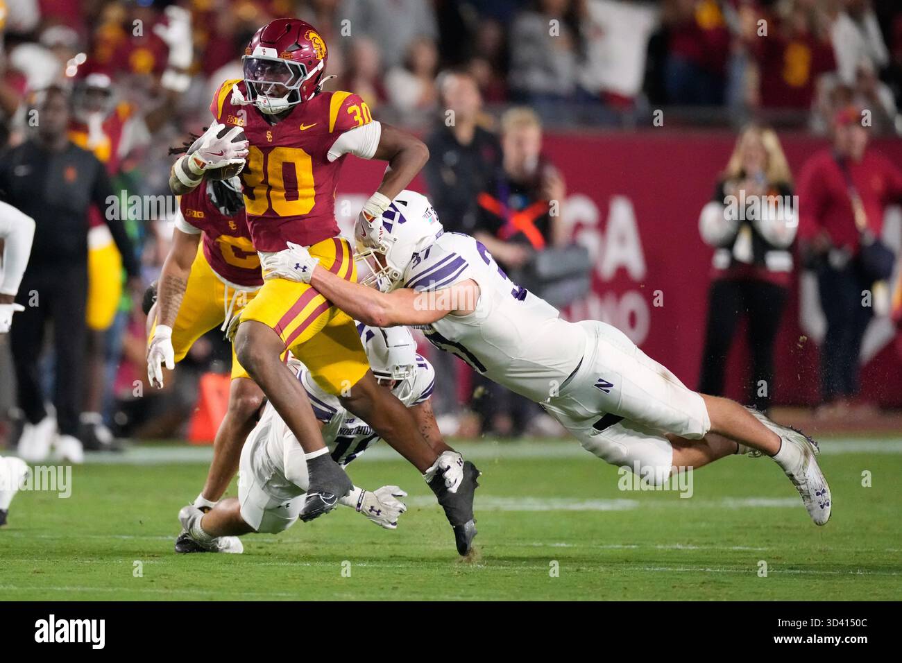 Southern California running back King Miller, left, breaks a tackle by ...