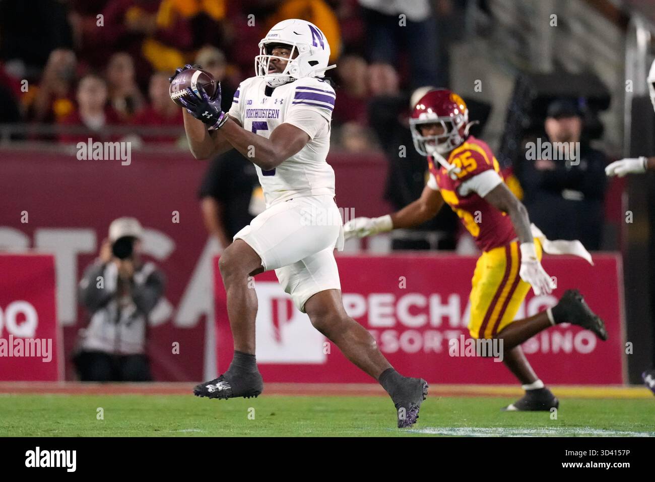 Northwestern running back Caleb Komolafe, left, catches a pass as ...