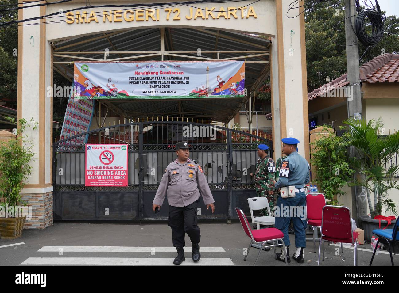 Police officers and military personnel stand guard at the gate of a ...