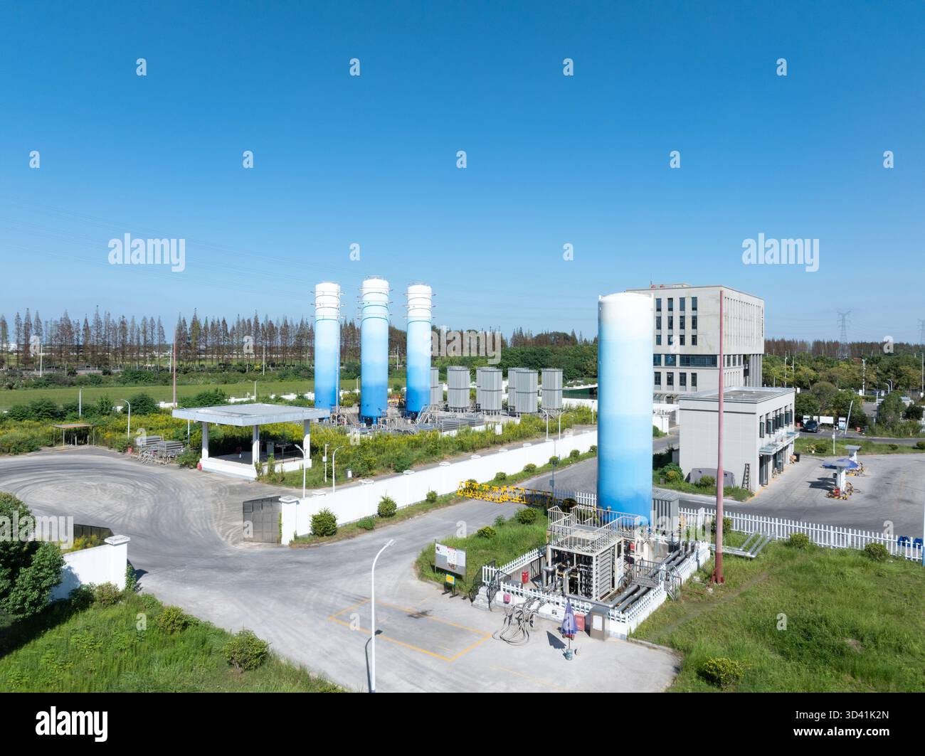 Industrial gas facility with blue towers, pipes, and power lines in ...