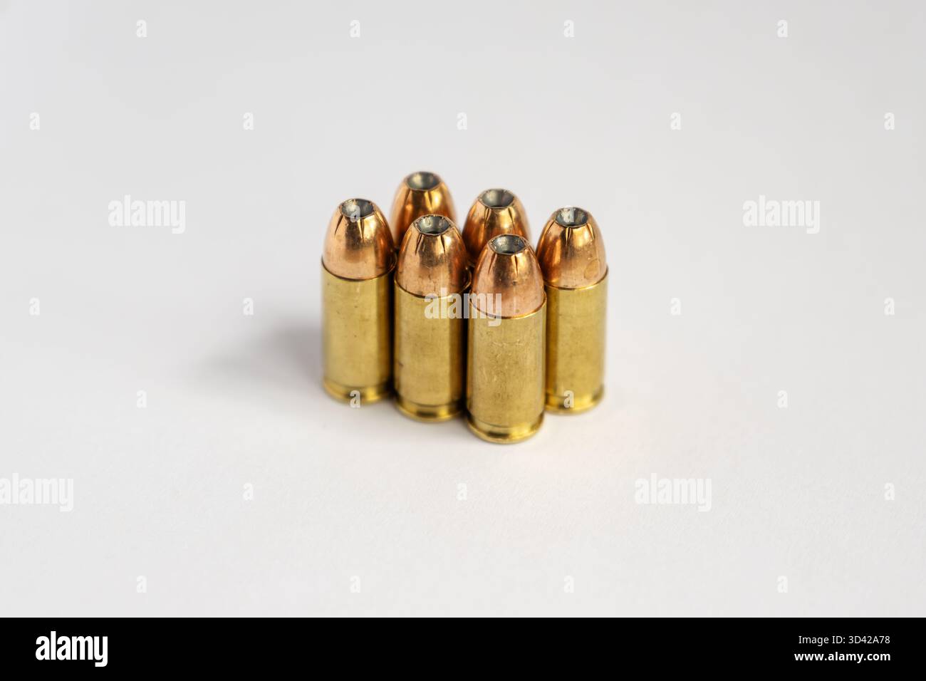 Six hollow point bullets standing on white background Stock Photo - Alamy